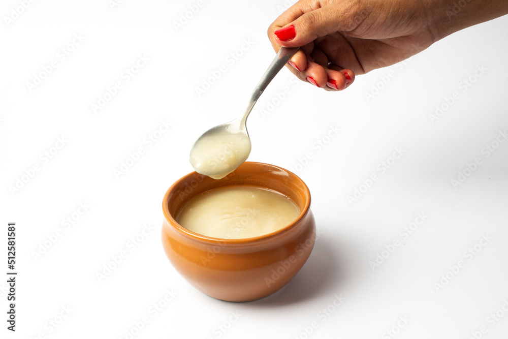 Pure cow ghee in ceramic bowl on white background with ghee spoon in ...