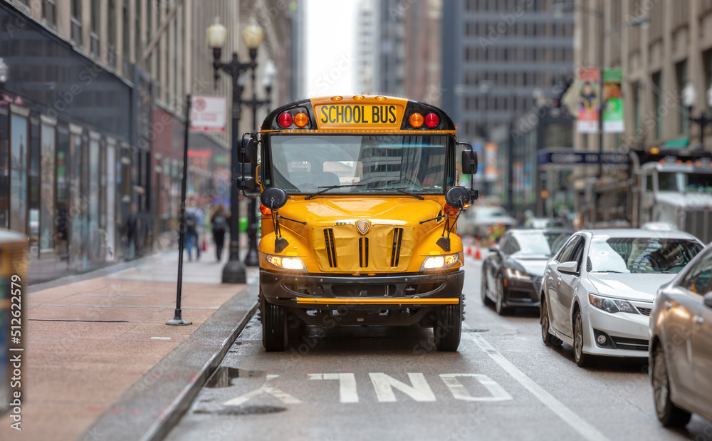 School bus USA. Yellow classic public bus on the street, only bus lane, American city downtown ...