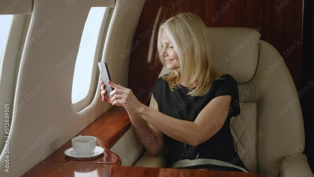 Beautiful mature woman millionaire taking photos with smartphone from ...