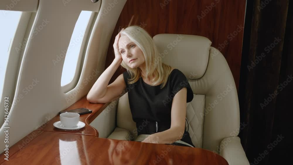Sad rich mature business woman travels on private plane. Portrait of ...