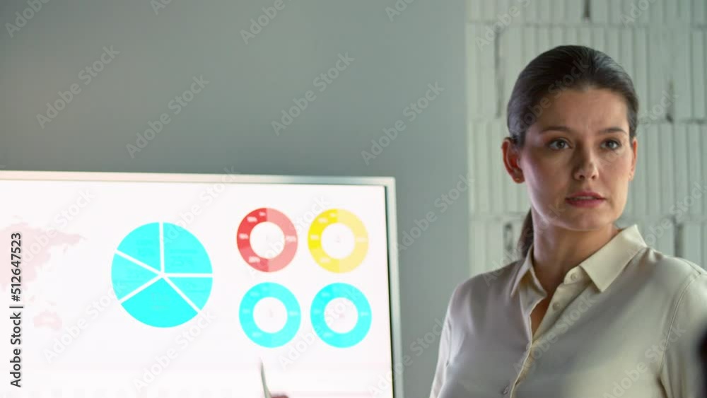 Mature woman answering questions after presentation using tv ...