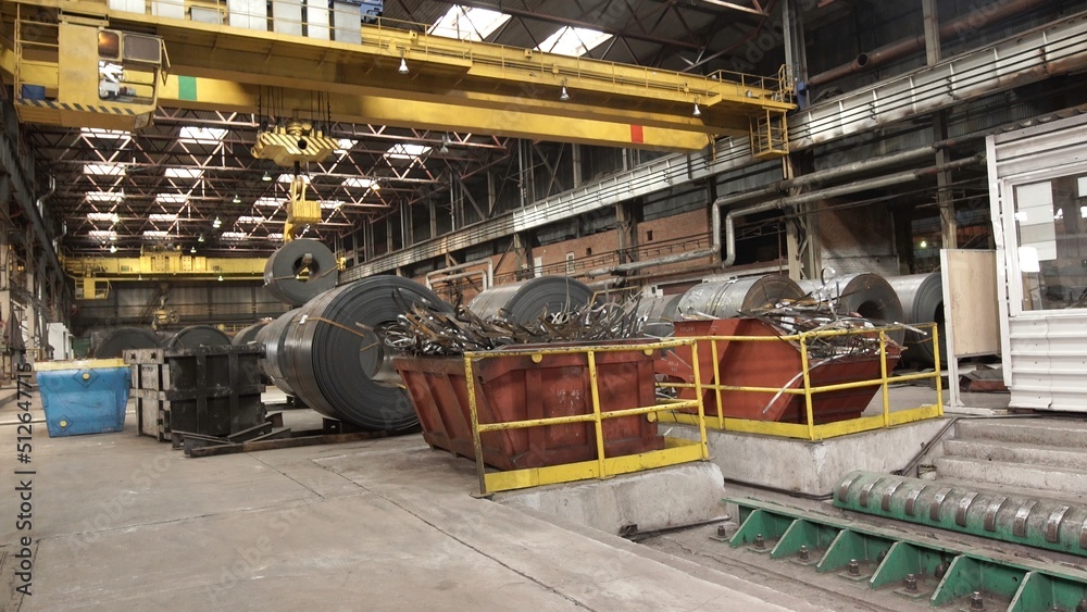 An overhead crane - Coil tong carrying a steel coil to a designated ...