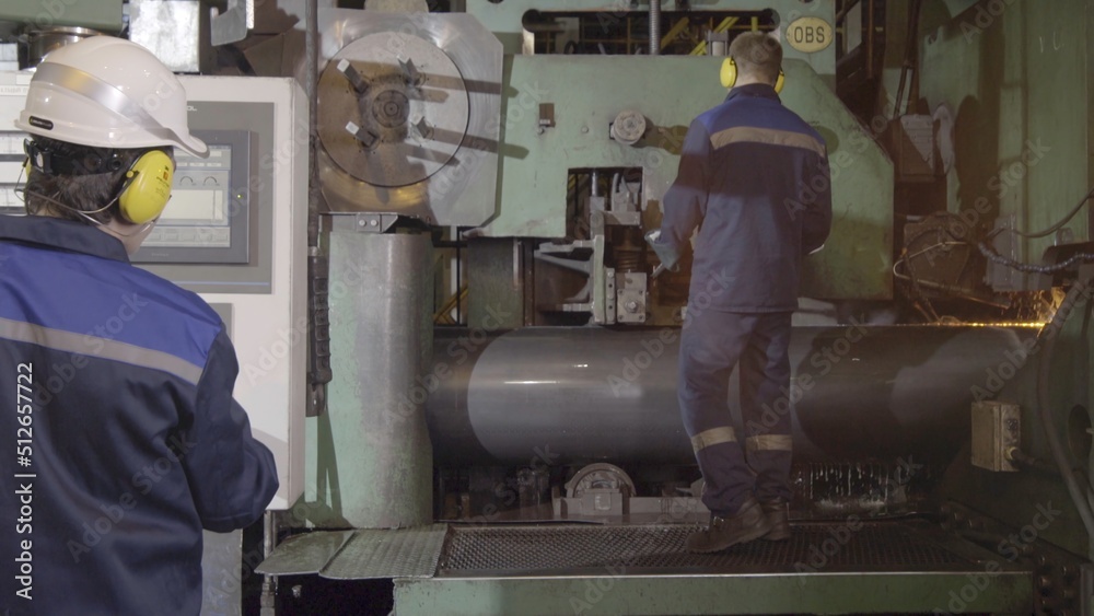 Making metal pipes and tubes in an engineering factory. Worker on the ...