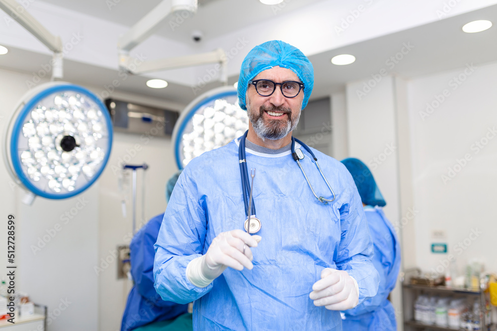 Portrait of male surgeon standing in operating room, ready to work on a ...
