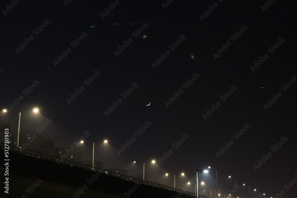 Moon in the night sky, and small lights Stock Photo | Adobe Stock