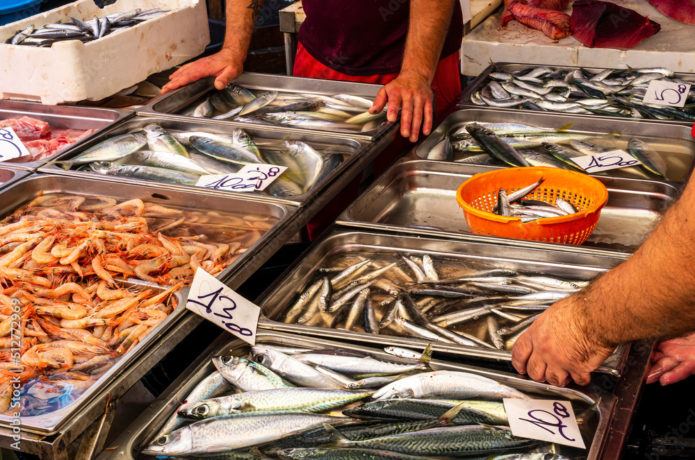 fish on a city seafood market during trading day, fish trader during ...