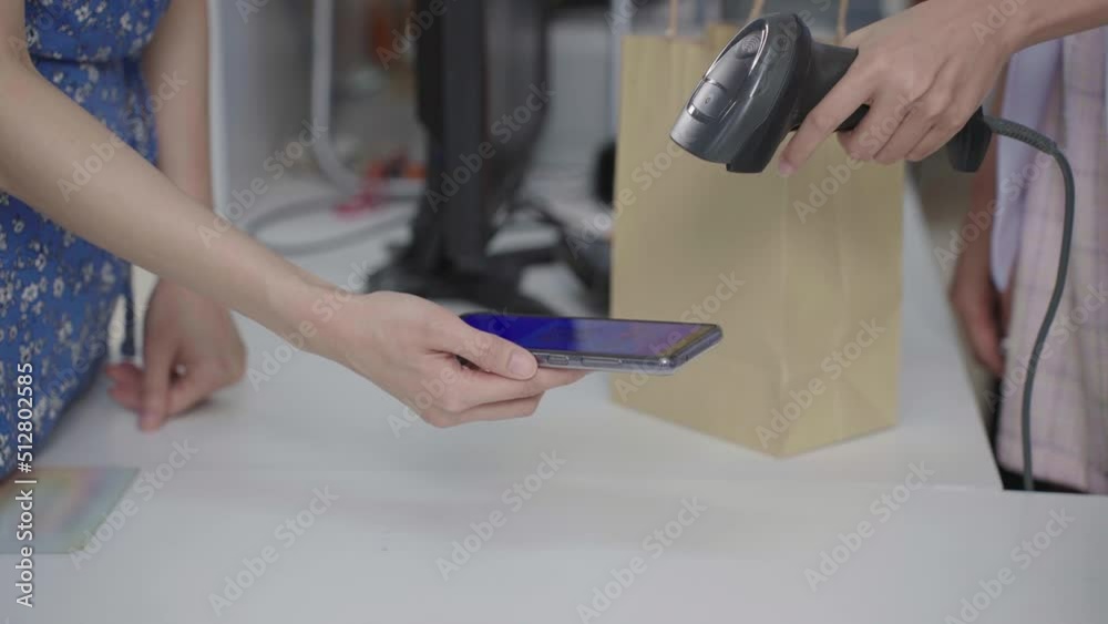 Close-up hand of woman is paying with an electronic wallet on her ...