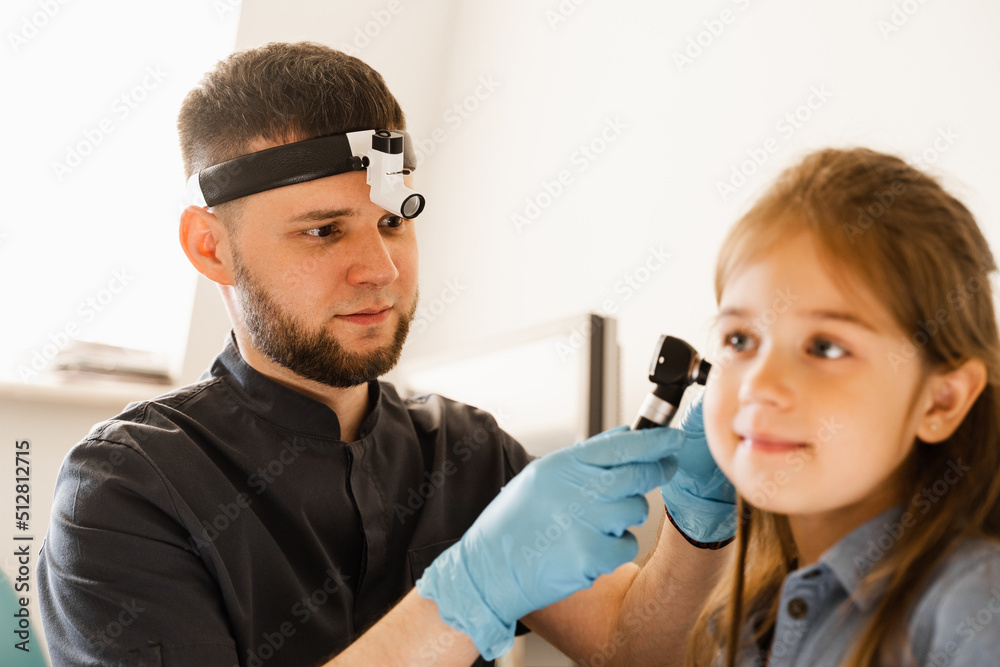 ENT doctor with otoscope. Otoscopy. Pediatrician otolaryngologist looks ...