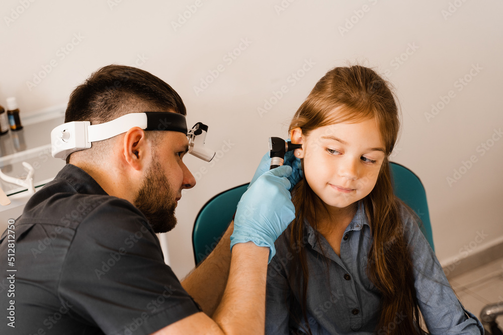 ENT doctor with otoscope. Otoscopy. Pediatrician otolaryngologist looks ...