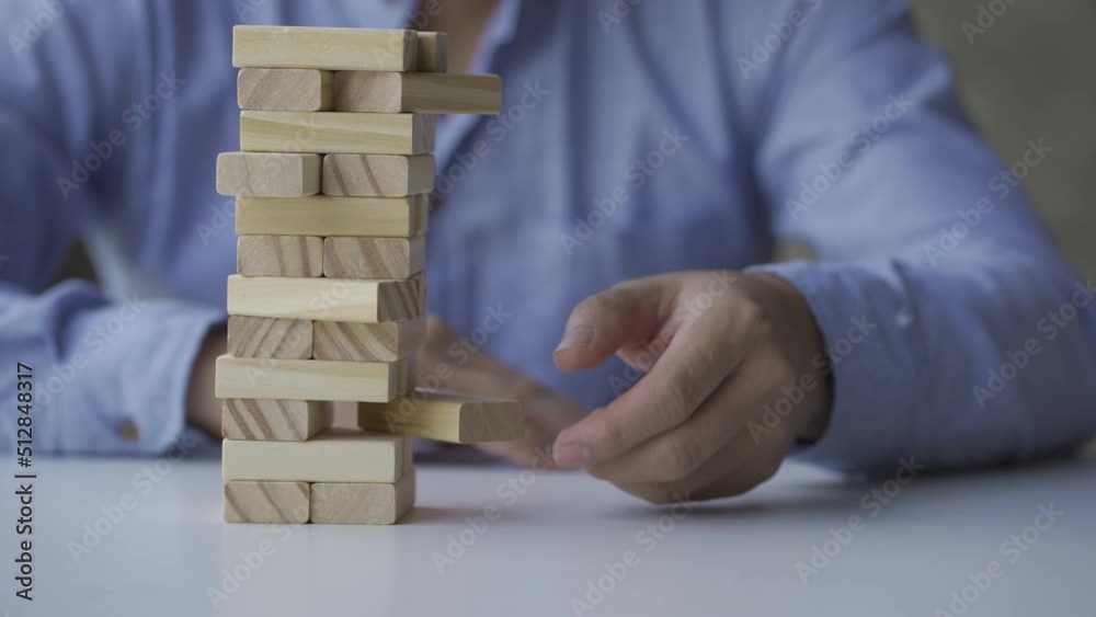 Businessman's hand pulling a wooden block Failed to build an ...