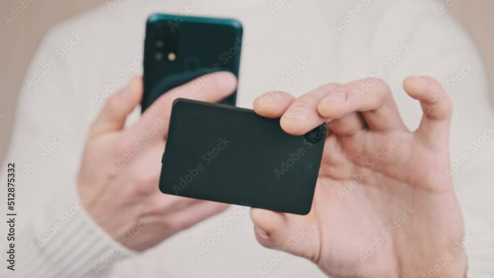 Young man with a smartphone scan QR code on the cold crypto wallet and ...