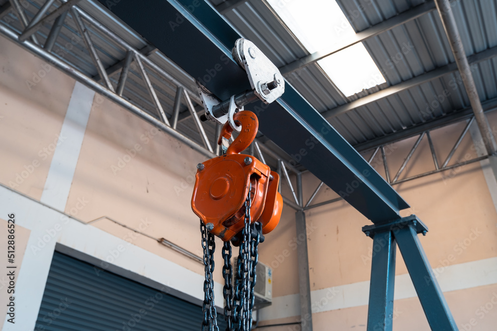 The construction crane in factory. chain hoist hanging on steel box ...