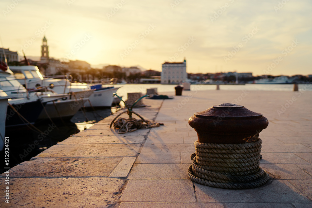 Iron bollard for mooring of ships at pier. Landscape with sea wharf ...