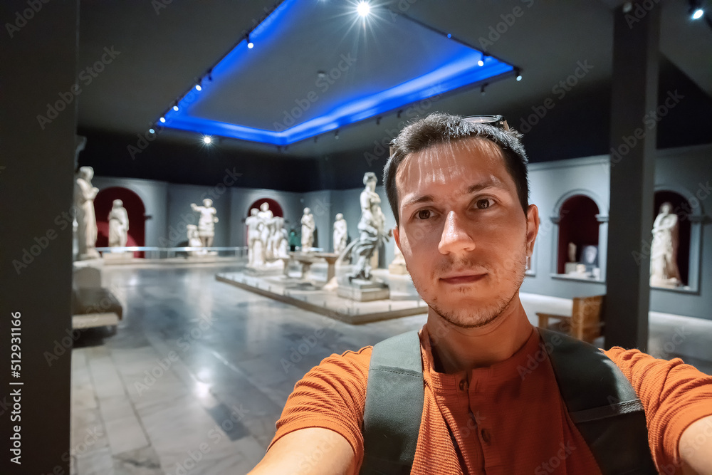 Man taking selfie photo in the hall with Greek antique statues of women ...