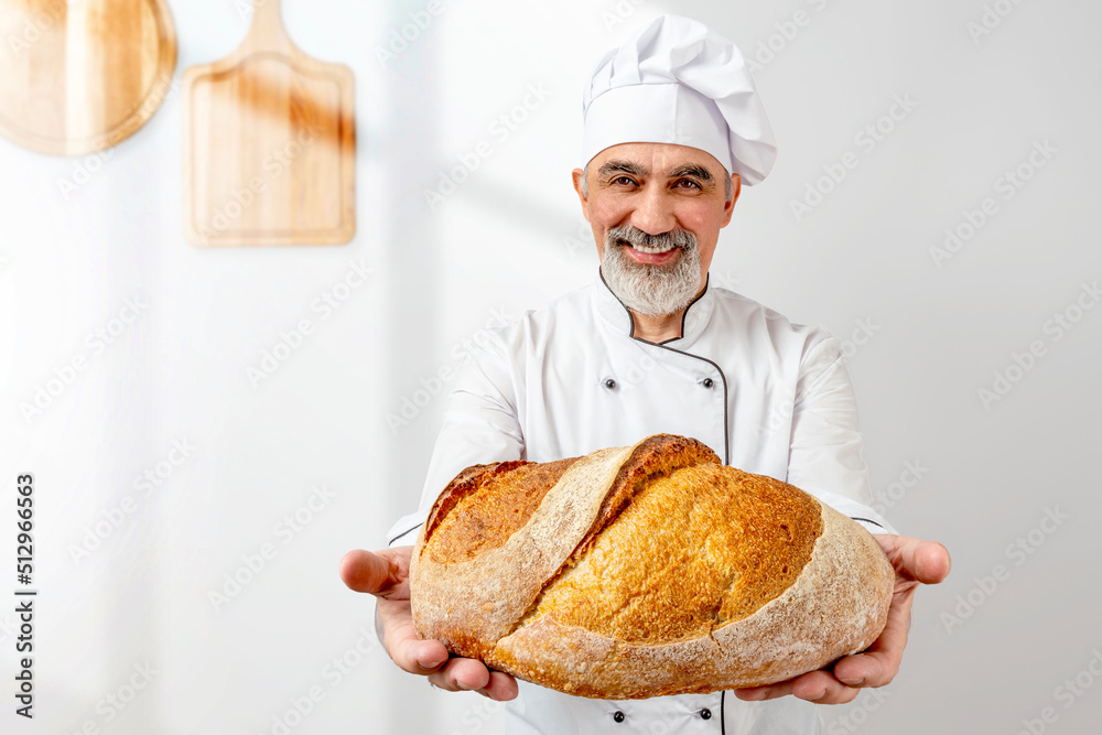 Foto de Professional baker offering freshly baked bread. Chef-cooker in ...