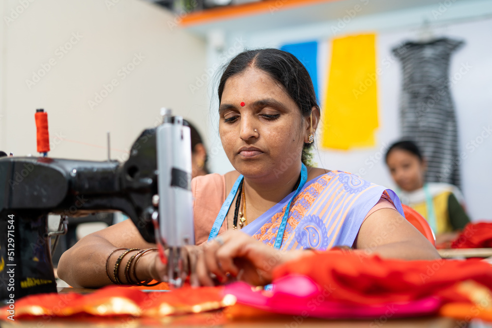 Garment employees seriously working on cloth sewing at factory- concept ...
