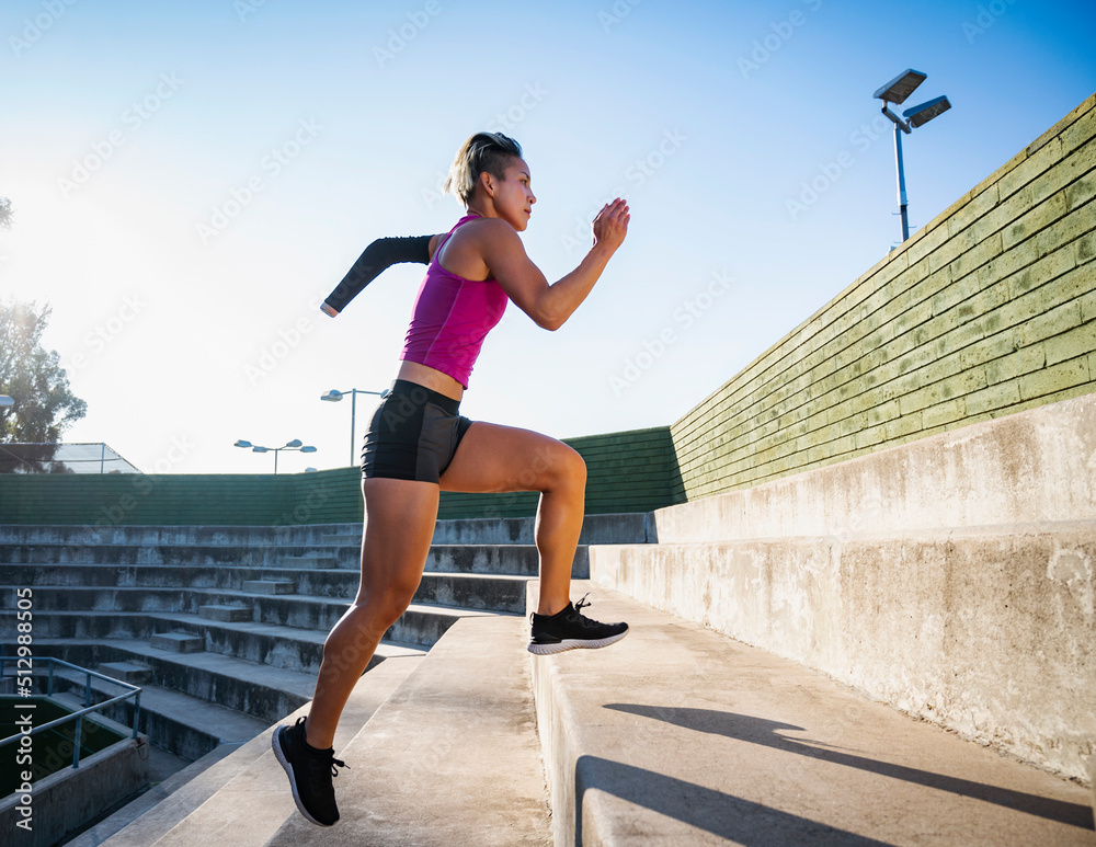 Athletic woman with amputated hand running up steps Stock Photo | Adobe ...