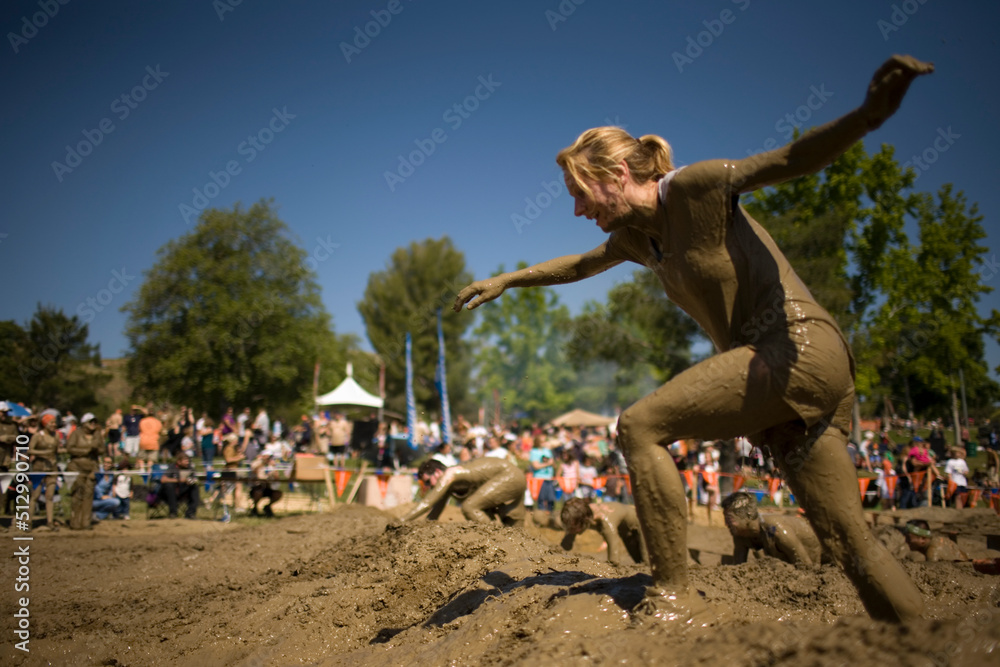 Sportswoman running in mud Stock Photo | Adobe Stock