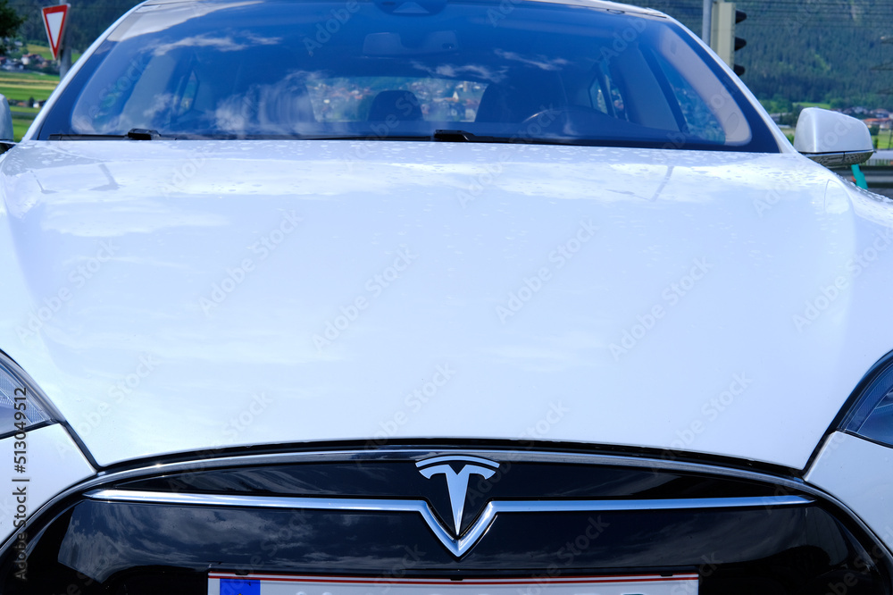 white Tesla light electric car stands in parking lot in front of office ...