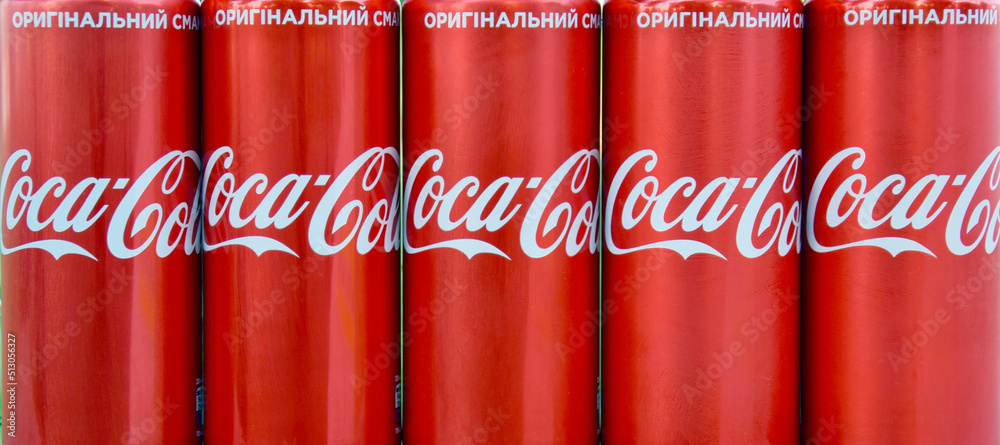 Many cans of Coca-Cola soda with background blurring in a park. Stock ...