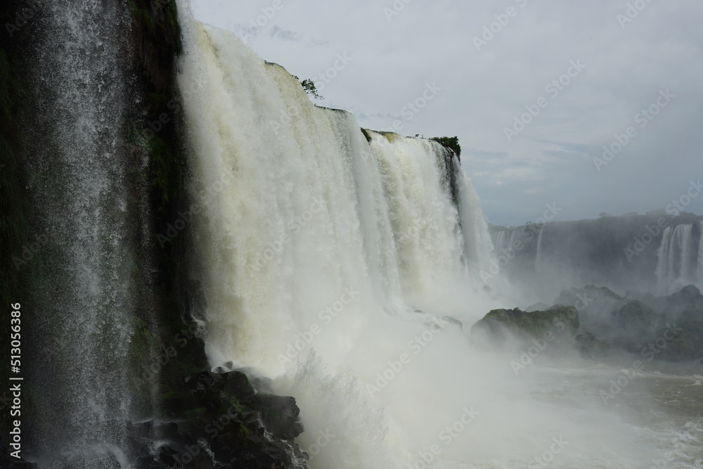 The photo shows a beautiful landscape of Iguazu Falls — a complex of ...