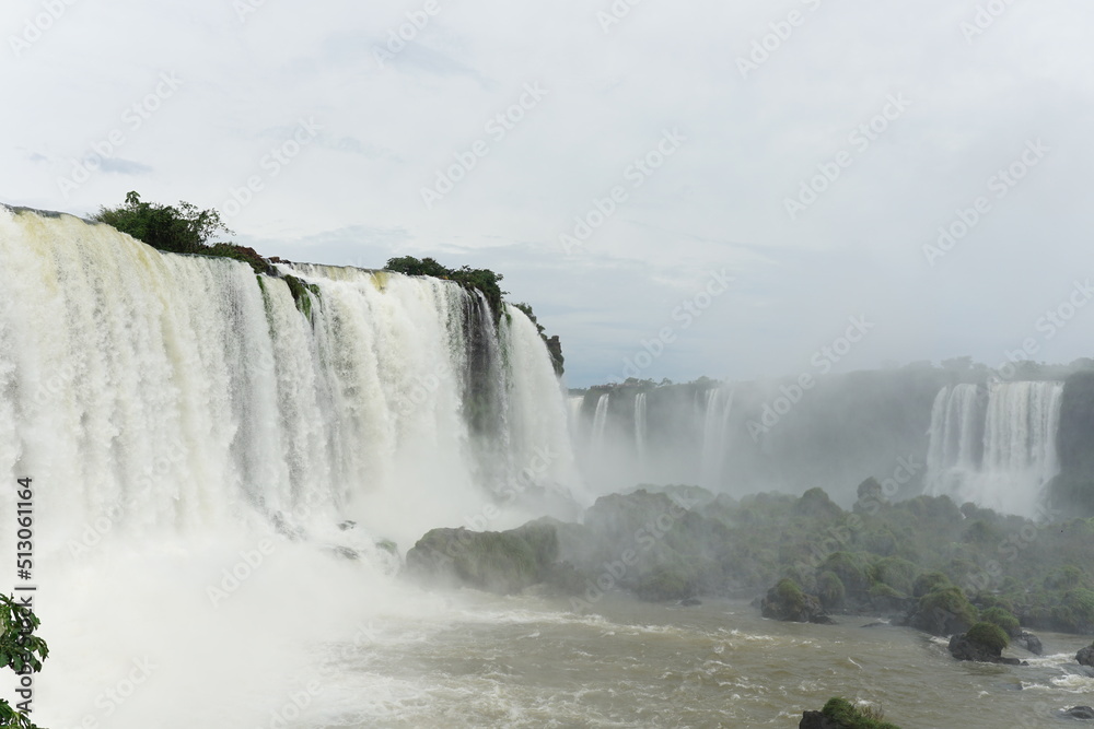 The photo shows a beautiful landscape of Iguazu Falls — a complex of ...