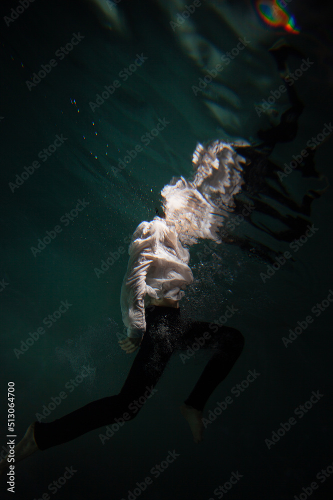 Beautiful underwater shooting, guy in white shirt and pants has fallen ...