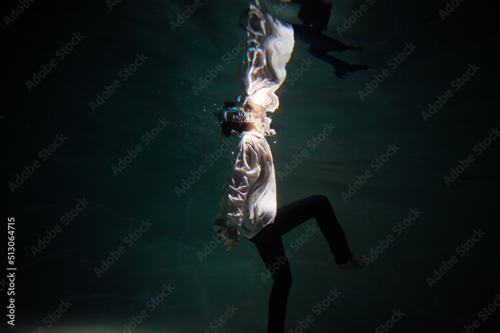 Beautiful underwater shooting, guy in white shirt and pants has fallen ...
