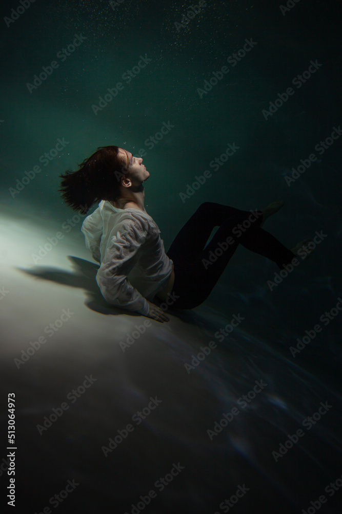Beautiful underwater shooting, guy in white shirt and pants has fallen ...
