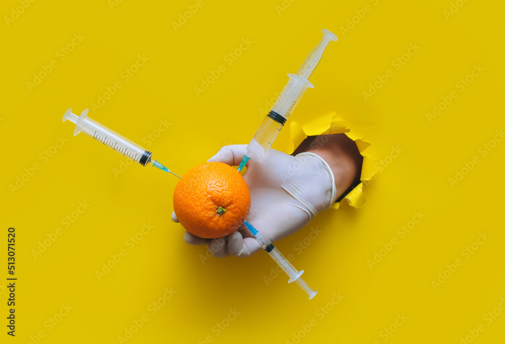A doctor's hand in a white latex medical glove holds an orange with ...