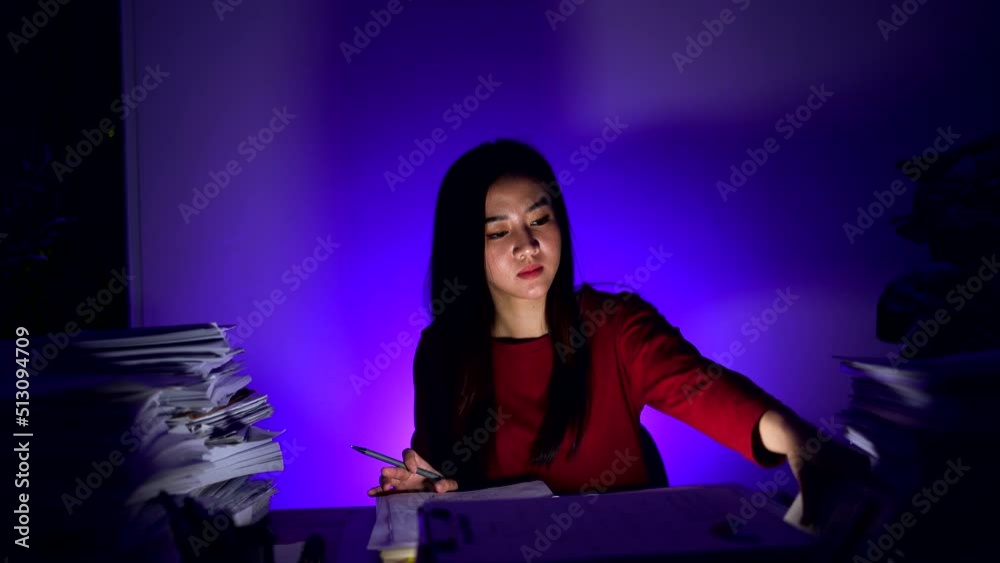 Asian businesswoman working hard late hours with a lot of document at ...