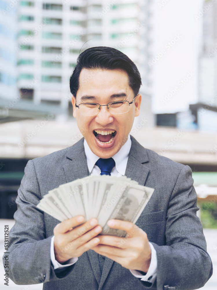 Excited happy face , Asian business man wear a suit holding money US ...