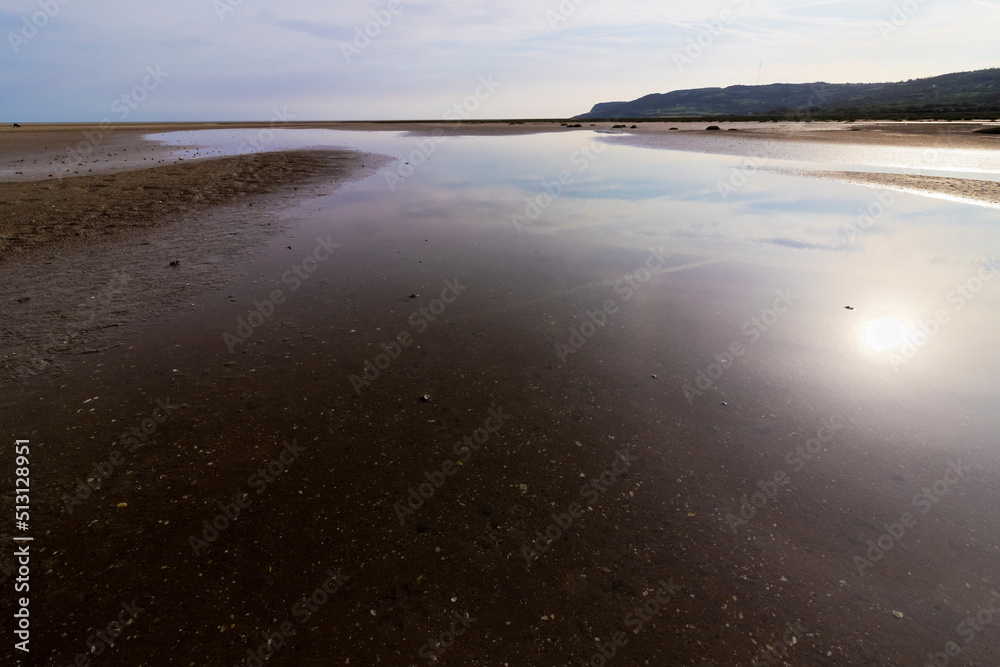 Striking coastline reflection of a circular sun halo on the water ...