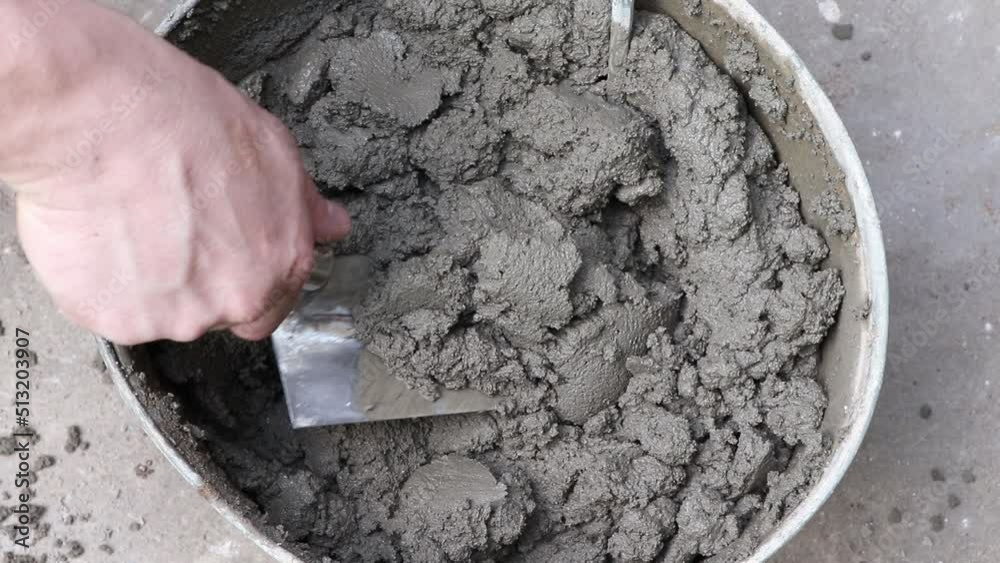 Mixing of concrete mortar.The builder prepares the cement mortar using ...