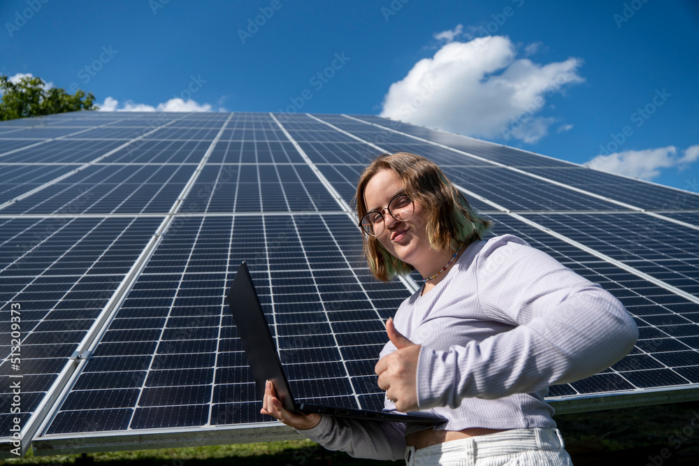 A young female engineer working with solar panels programs and ...