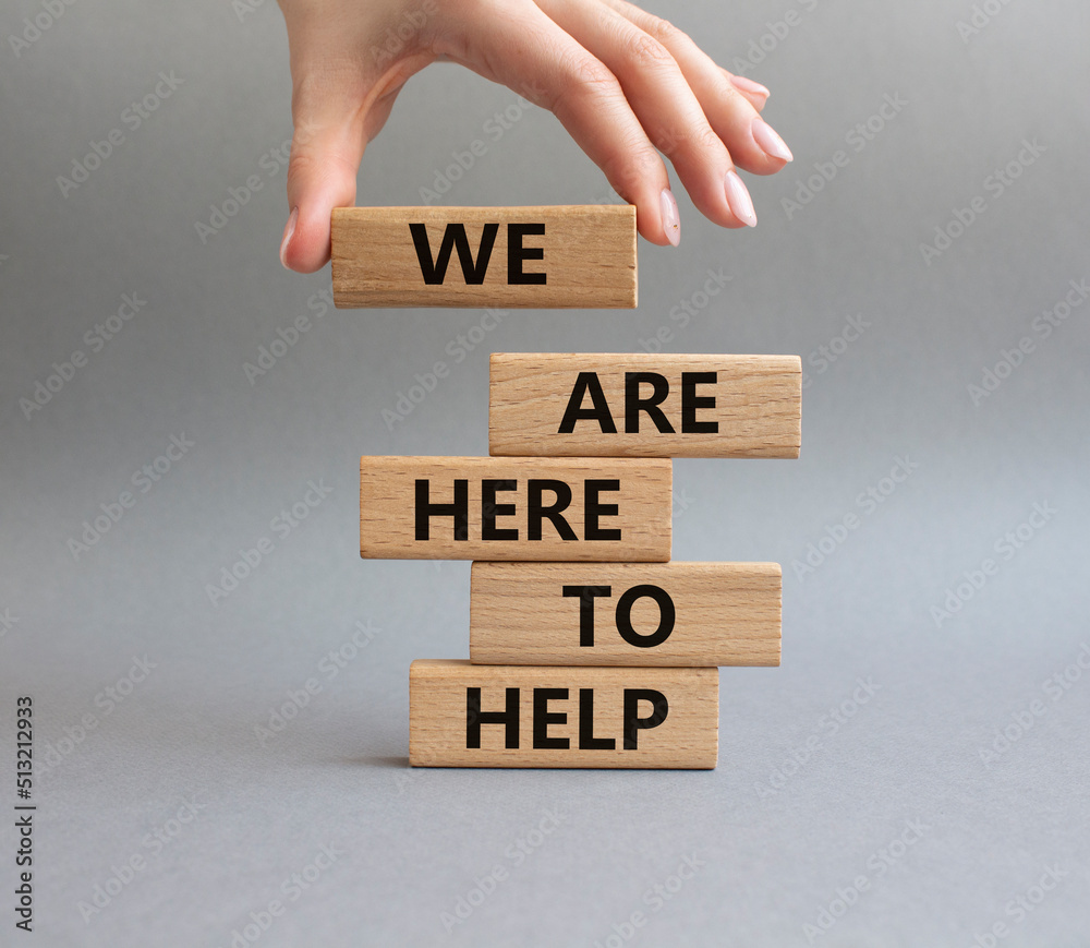 We are here to help symbol. Concept words we are here to help on wooden ...