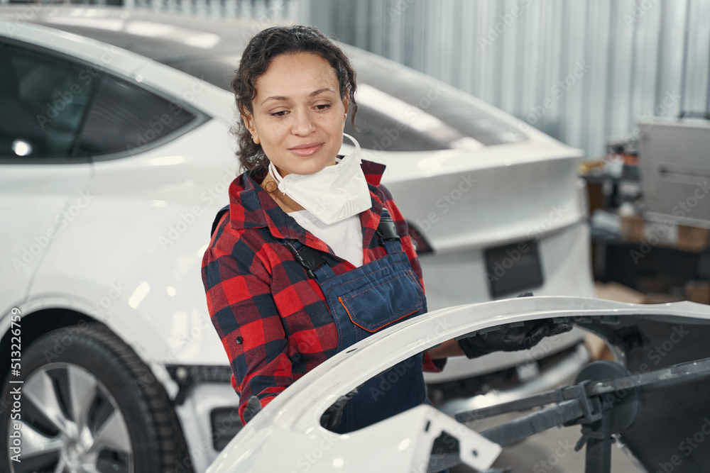 Delighted female mechanic checking the repaint of detail Stock Photo ...