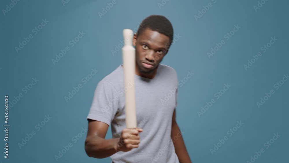 Aggressive upset rebel raising paddle at camera to fight, instigating ...