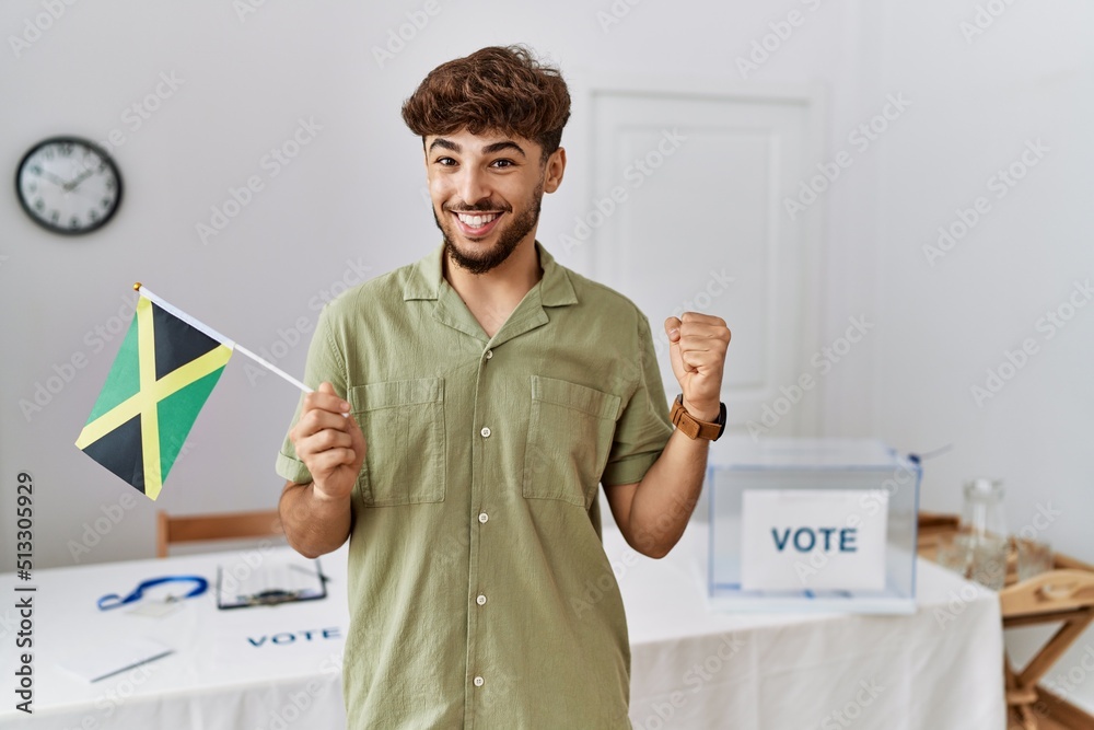 Young arab man at political campaign election holding jamaica flag ...