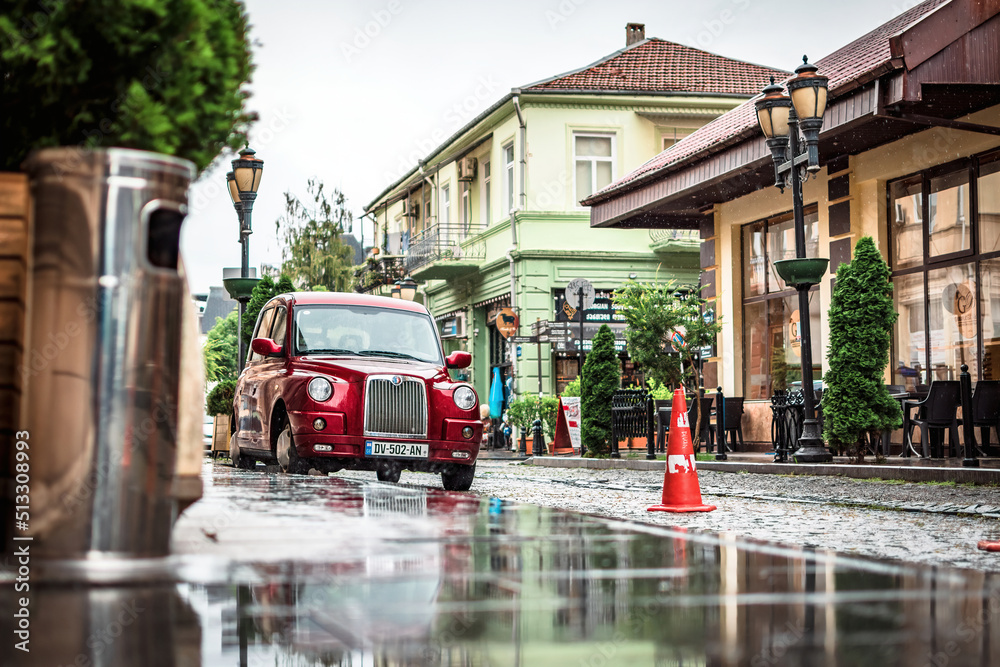 maroon color Hackney carriage car on rain city street in rainy Humidity ...