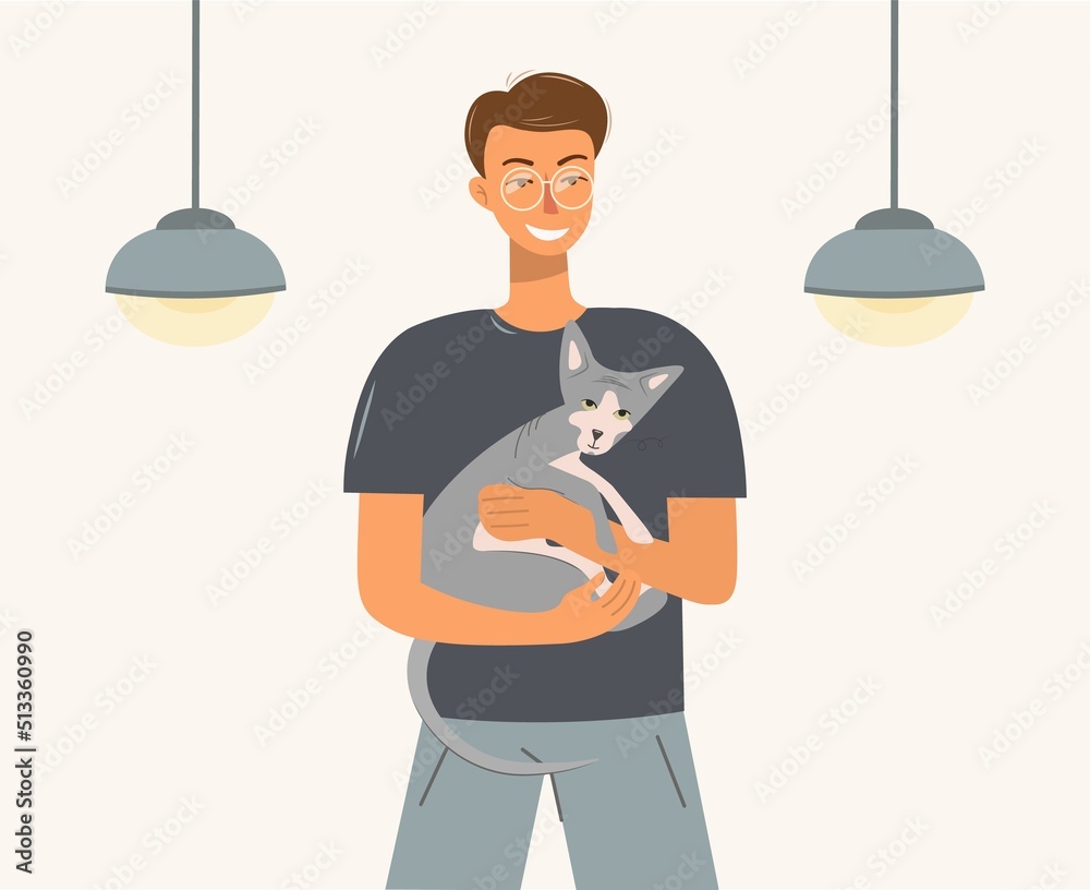 Smiling young man with a cat, a pet. Love and friendship with animals ...