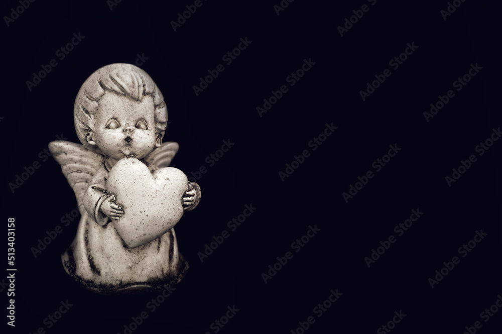 Sympathy card with angel holding a heart isolated on black background ...