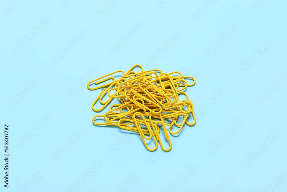 Yellow paper clips on blue background Stock-Foto | Adobe Stock