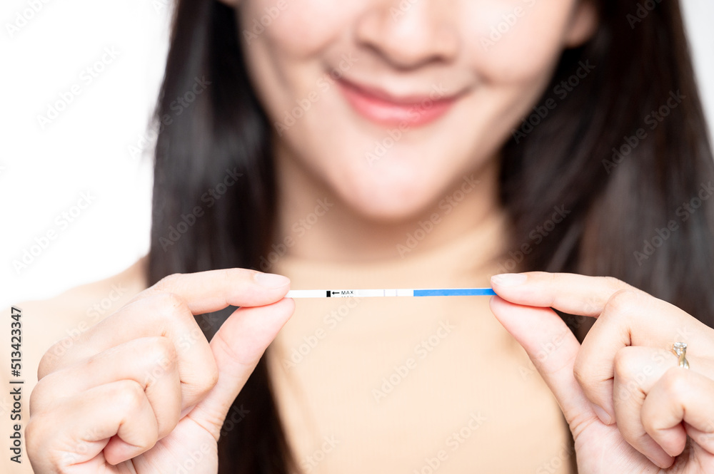 Happy asian woman shows a positive ovulation test. The concept of ...