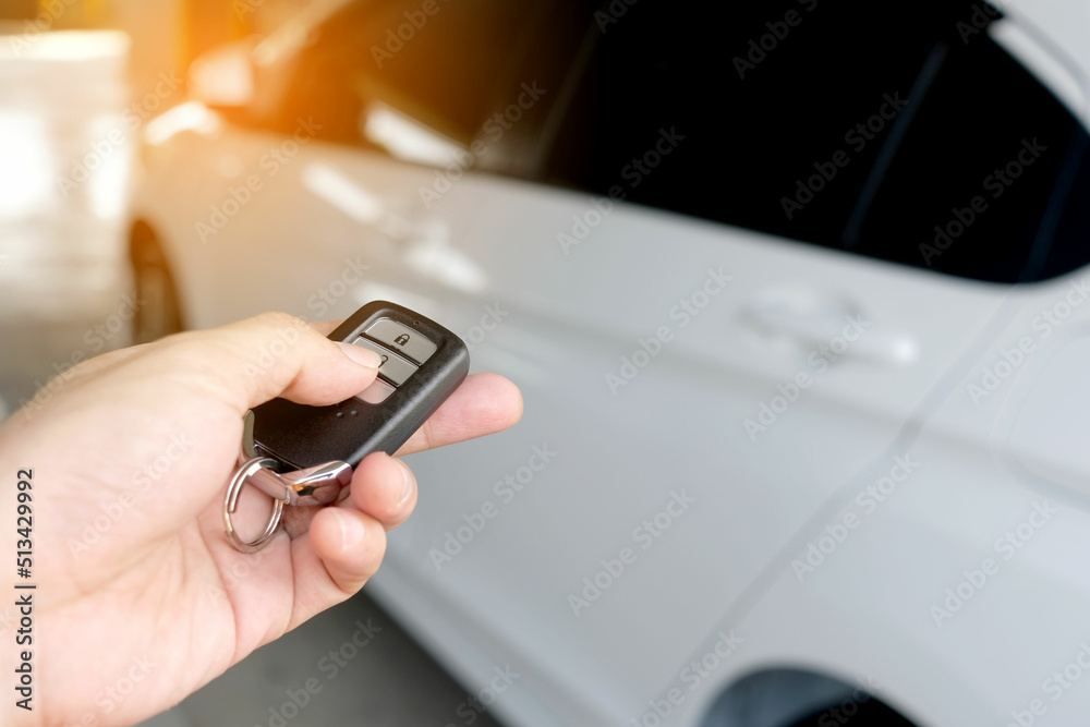 The man in the hand held the remote control of the car, he opened the ...