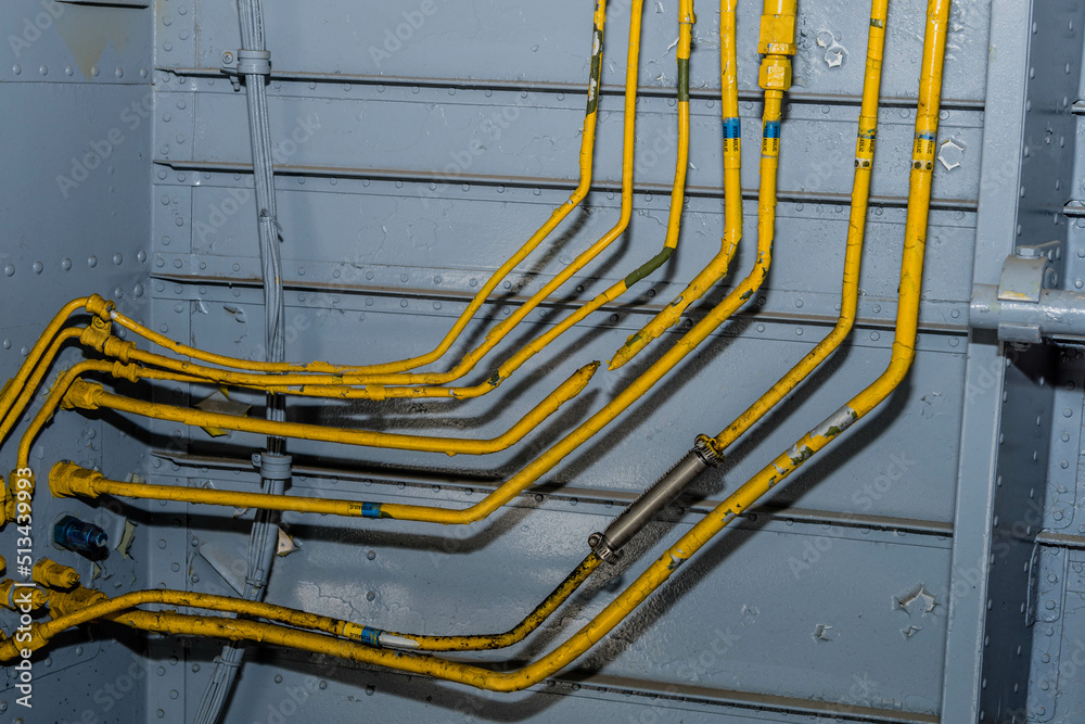 Exposed metal hydraulic lines secured to aircraft bulkheads in military ...