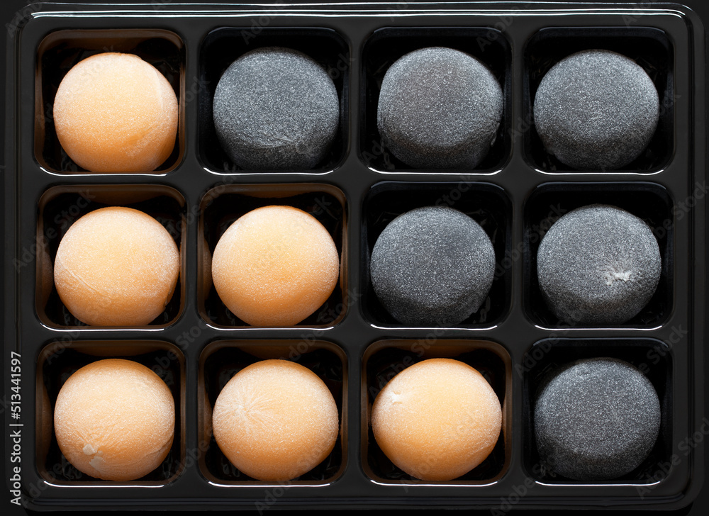 Top view of dark and light cakes in black plastic packaging. Daifuku ...