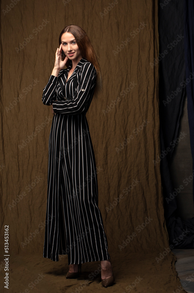 young girl with a slim figure in a black and white striped dress, full ...
