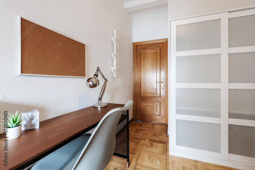 Room with industrial style wooden study table with gray resin chair and ...