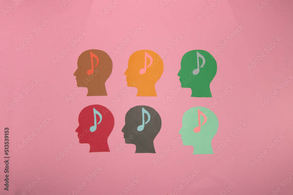 six colorful paper head with musical notes in the head on a pastel pink ...
